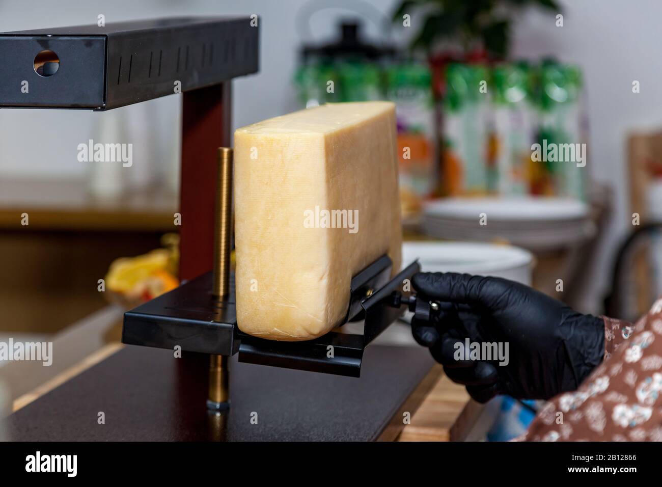A man is preparing raclette using a special metallic instrument during ...