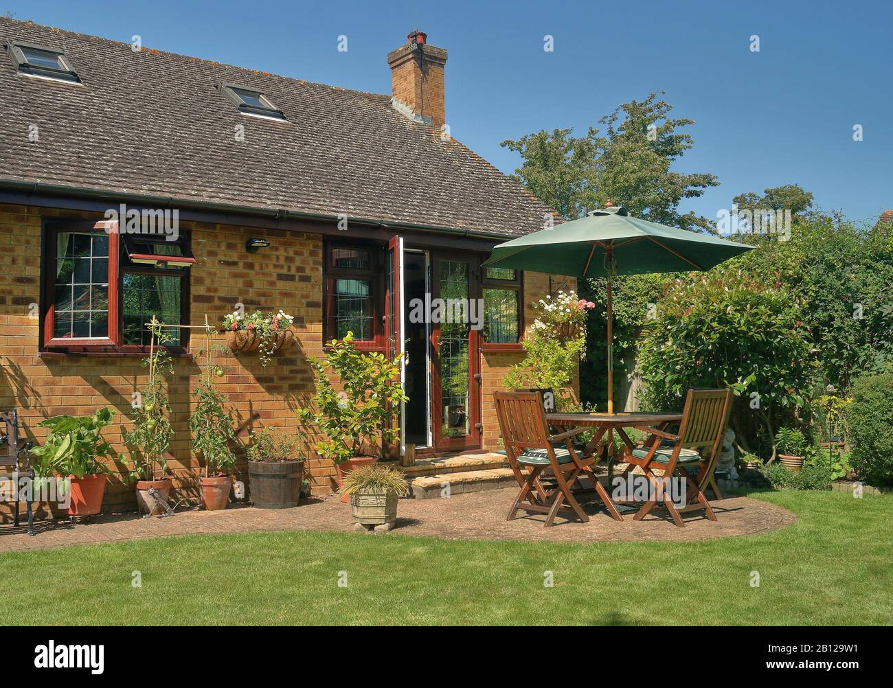 English back Garden Patio with table, chairs and parasol Stock Photo ...