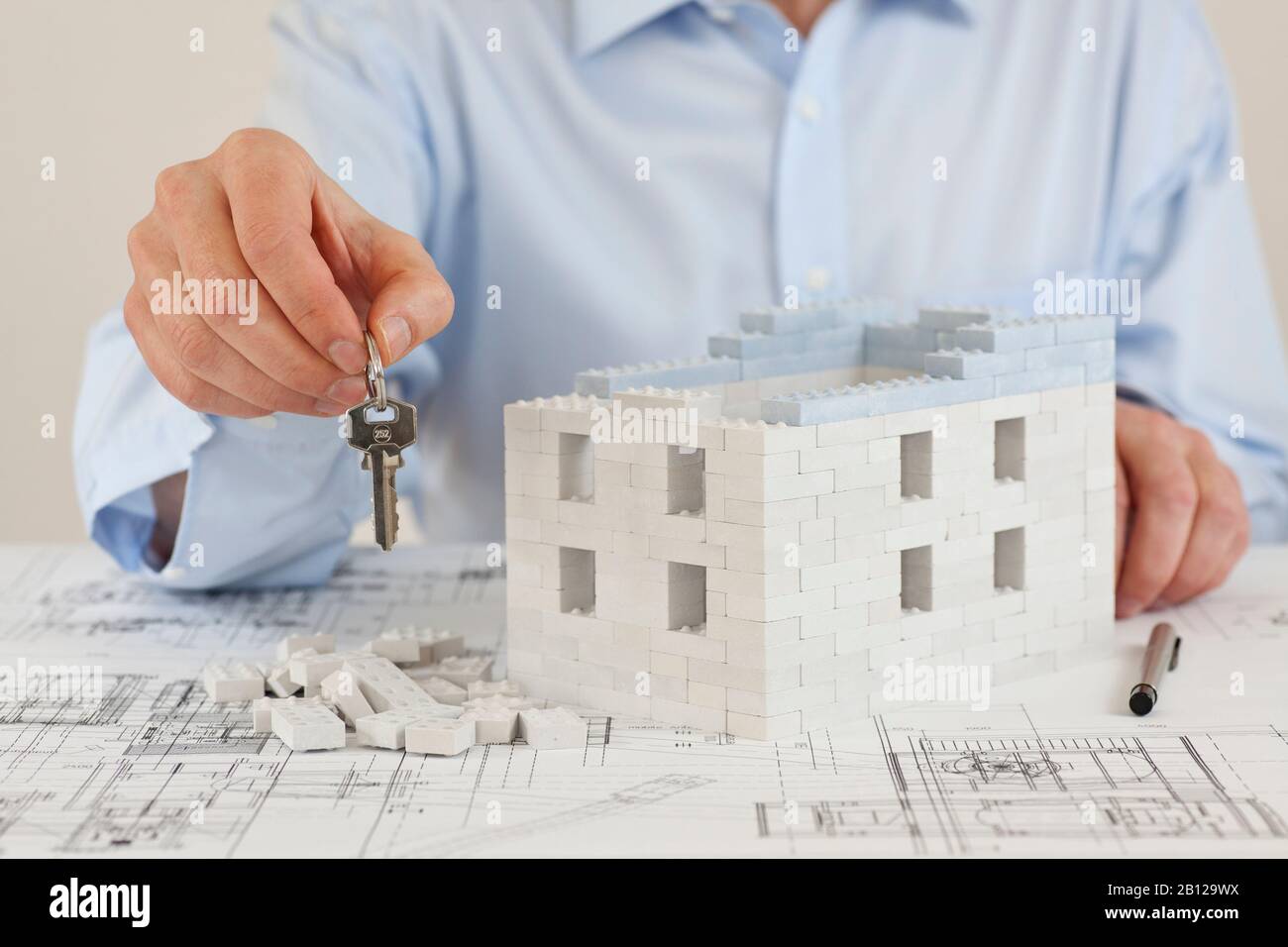 Architect presenting the keys for a house on construction plan Stock ...