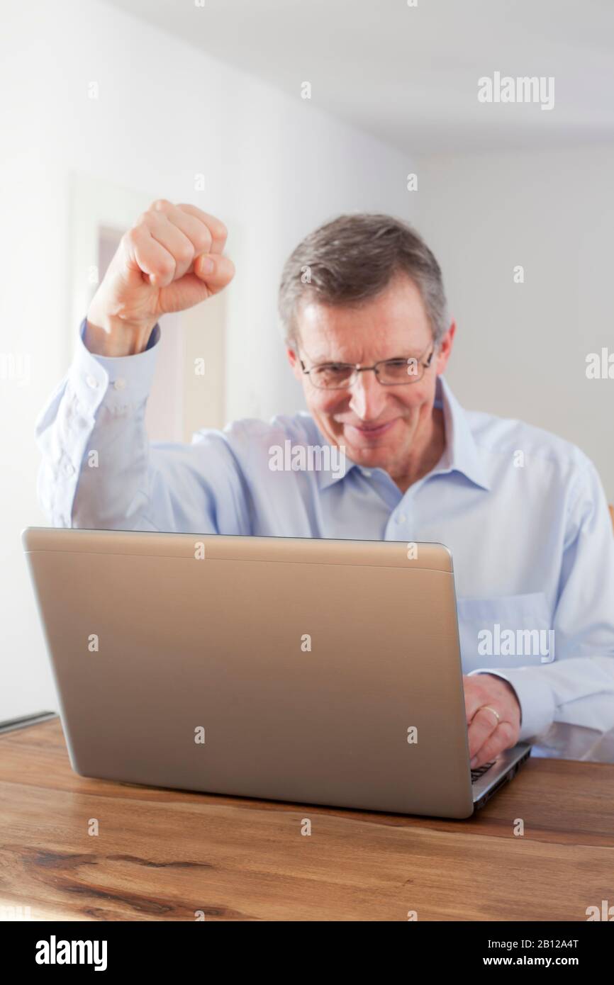 Happy man looking at laptop - focus on the edge of the laptop Stock ...