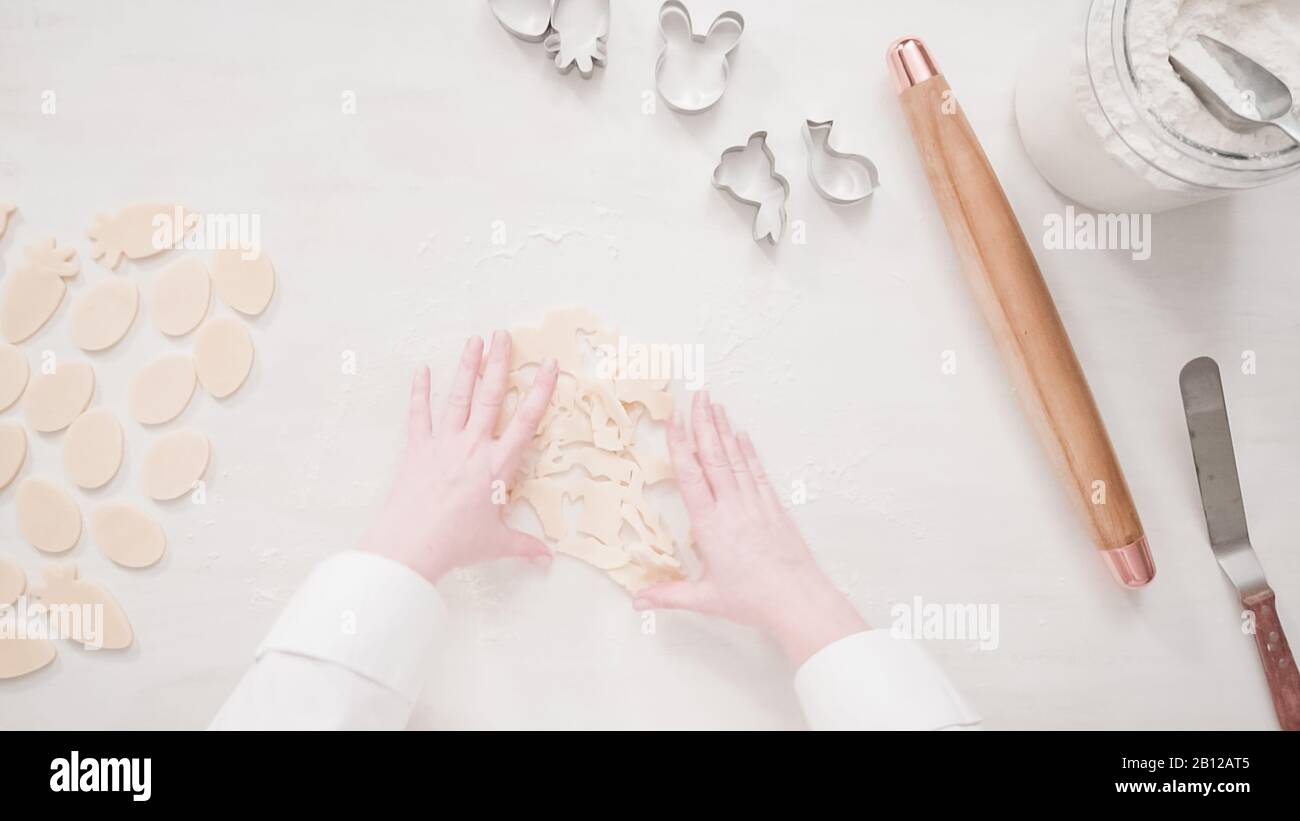 Step by step. Flat lay. Cutting sugar cookie dough with Easter shaped ...