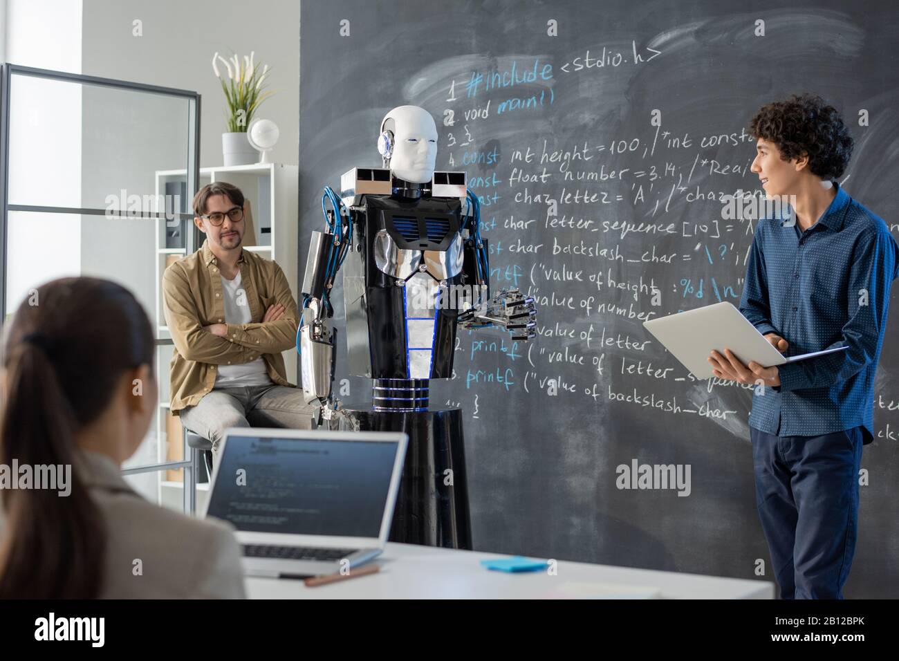 Contemporary young student with laptop making presentation of computer ...