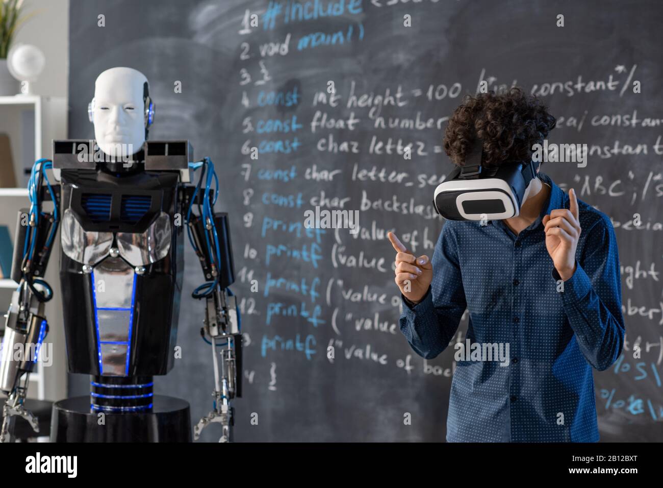 Student in vr headset operating by automation robot through virtual ...