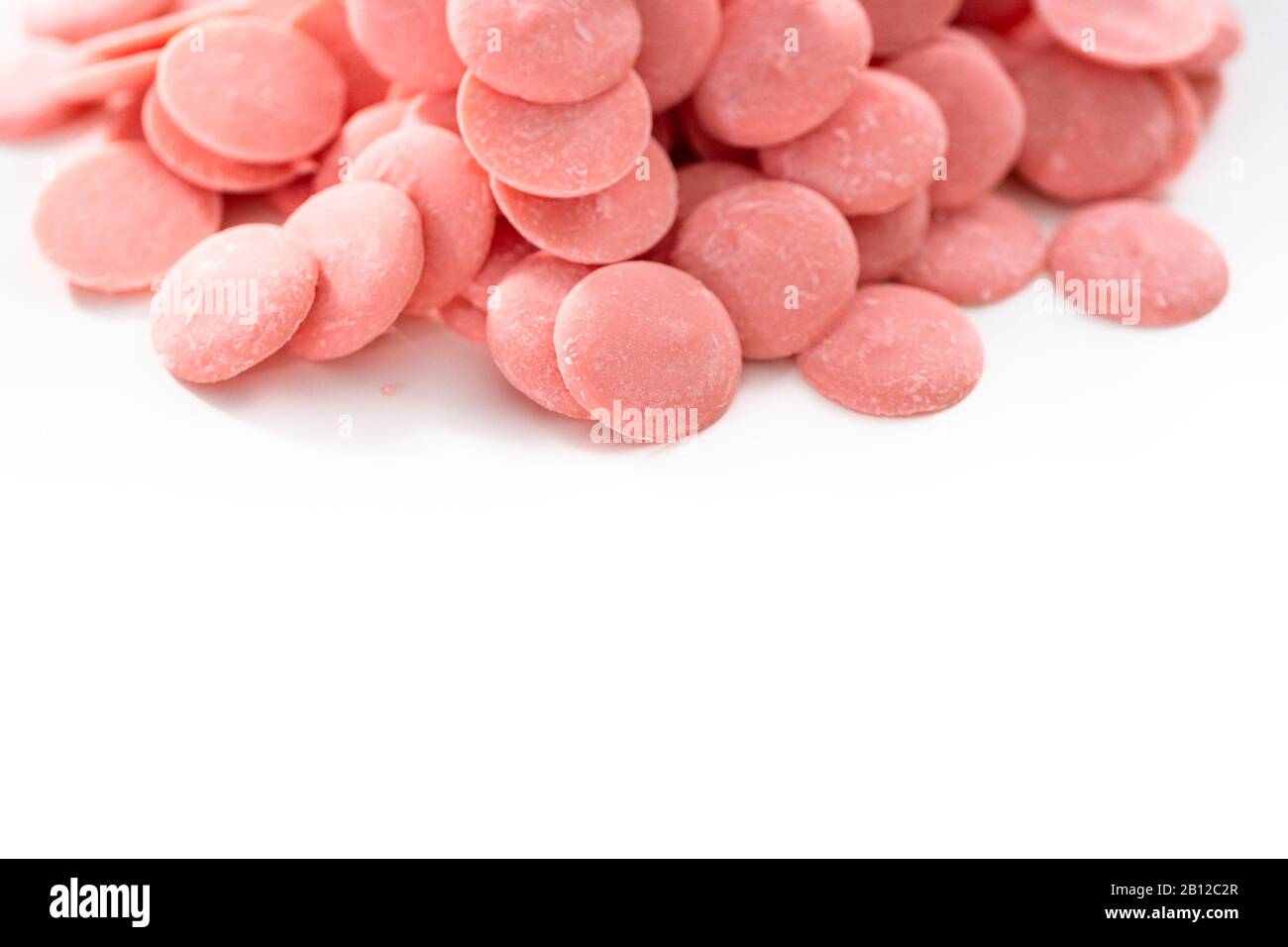 Pink round chocolate chips for melting chocolate shapes on a white ...