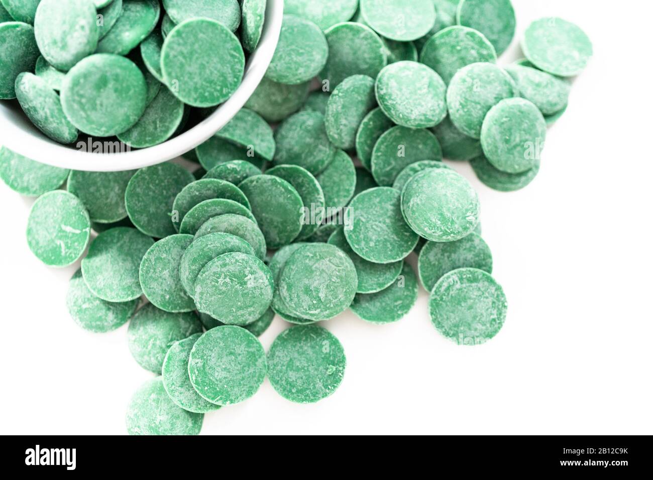Green round chocolate chips for melting chocolate shapes on a white ...