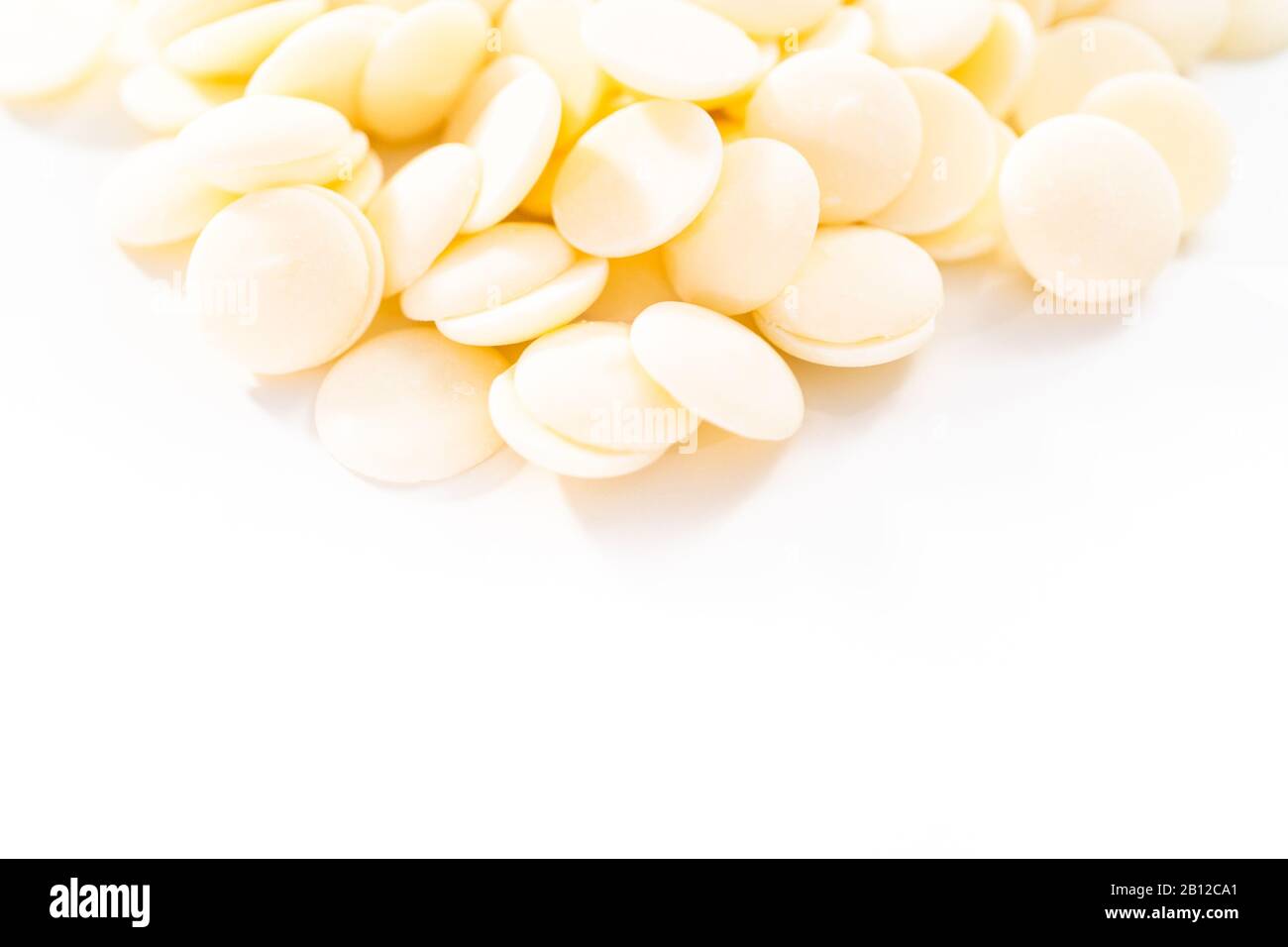 White round chocolate chips for melting chocolate shapes on a white ...