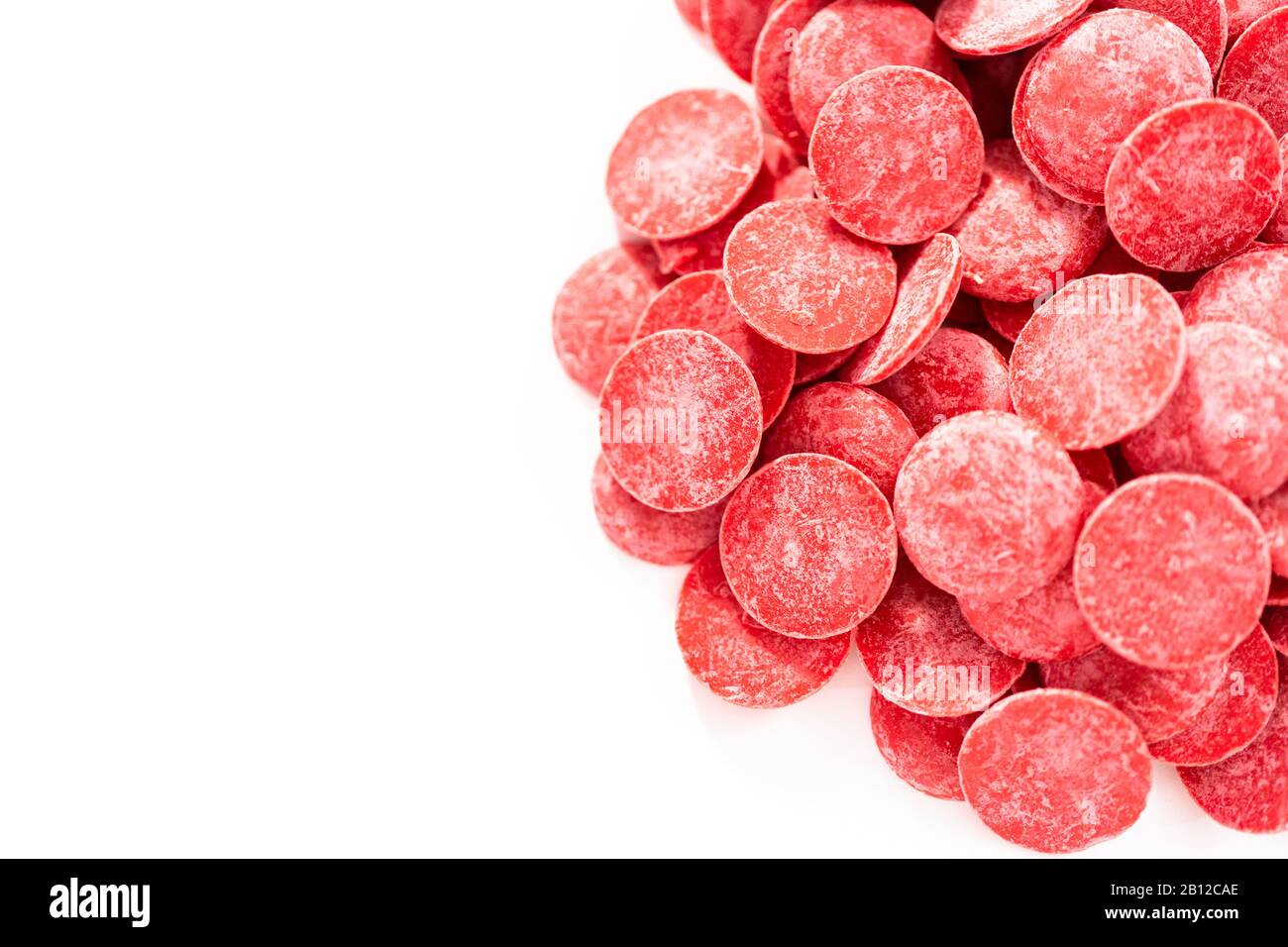 Red round chocolate chips for melting chocolate shapes on a white ...