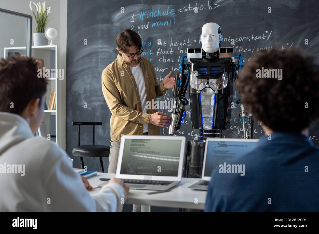 Teacher of technical university presenting automation robot to his ...
