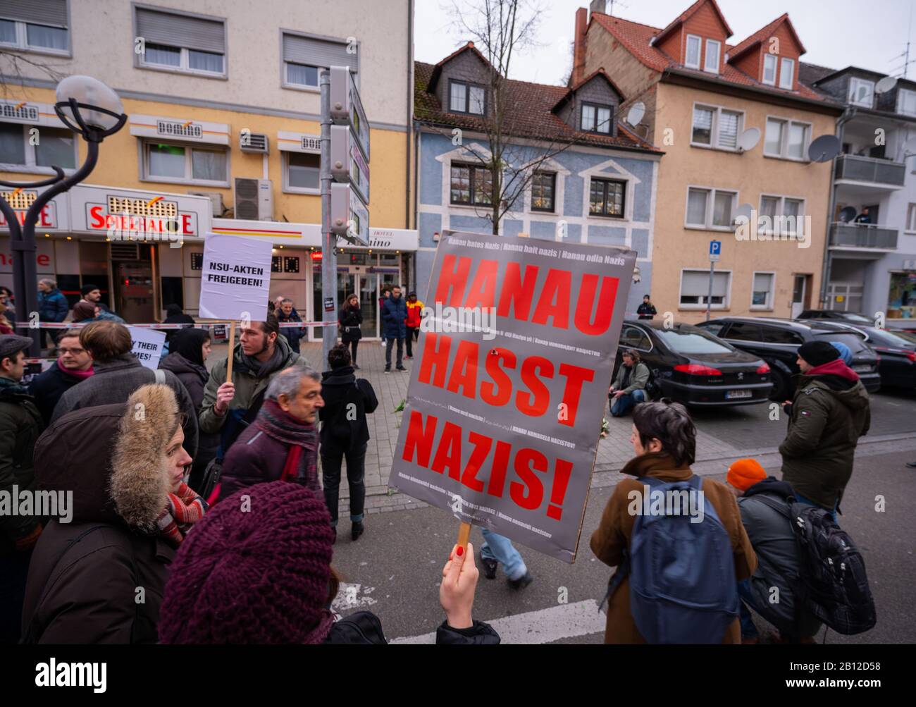 Hanau, Germany. 22nd Feb, 2020. A woman holds up a poster with the ...