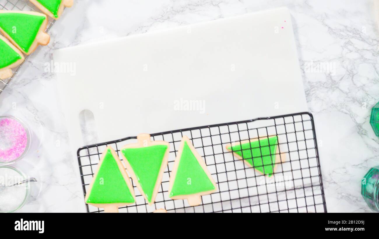 Flat lay. Stp by step. Icing Christmas tree-shaped sugar cookies with ...