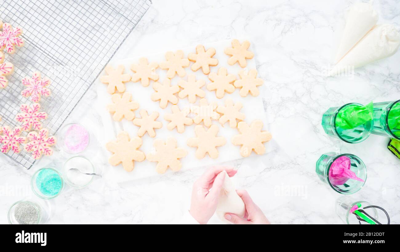 Flat lay. Stp by step. Icing snowflake shaped sugar cookies with white ...