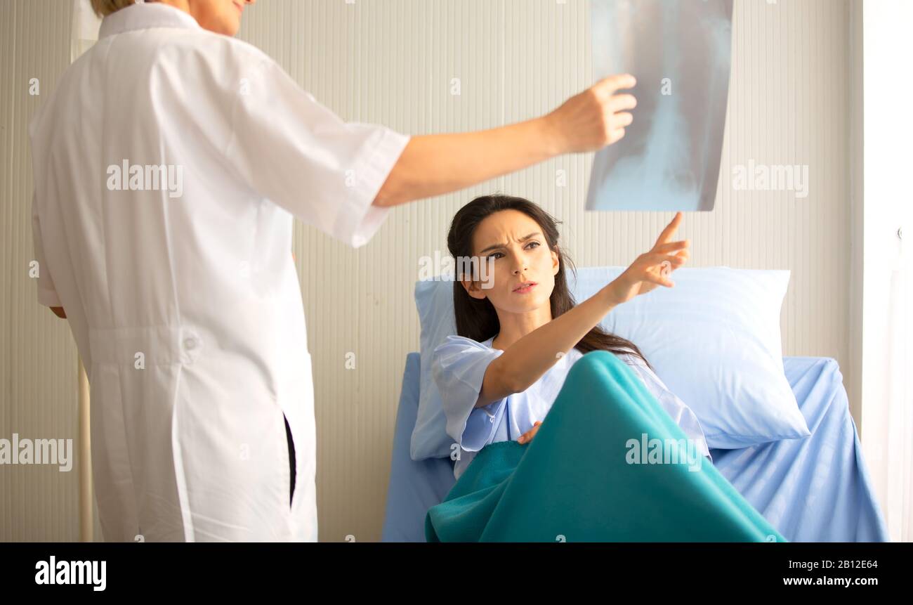 Women doctor explaining x-ray result to women patient Stock Photo - Alamy