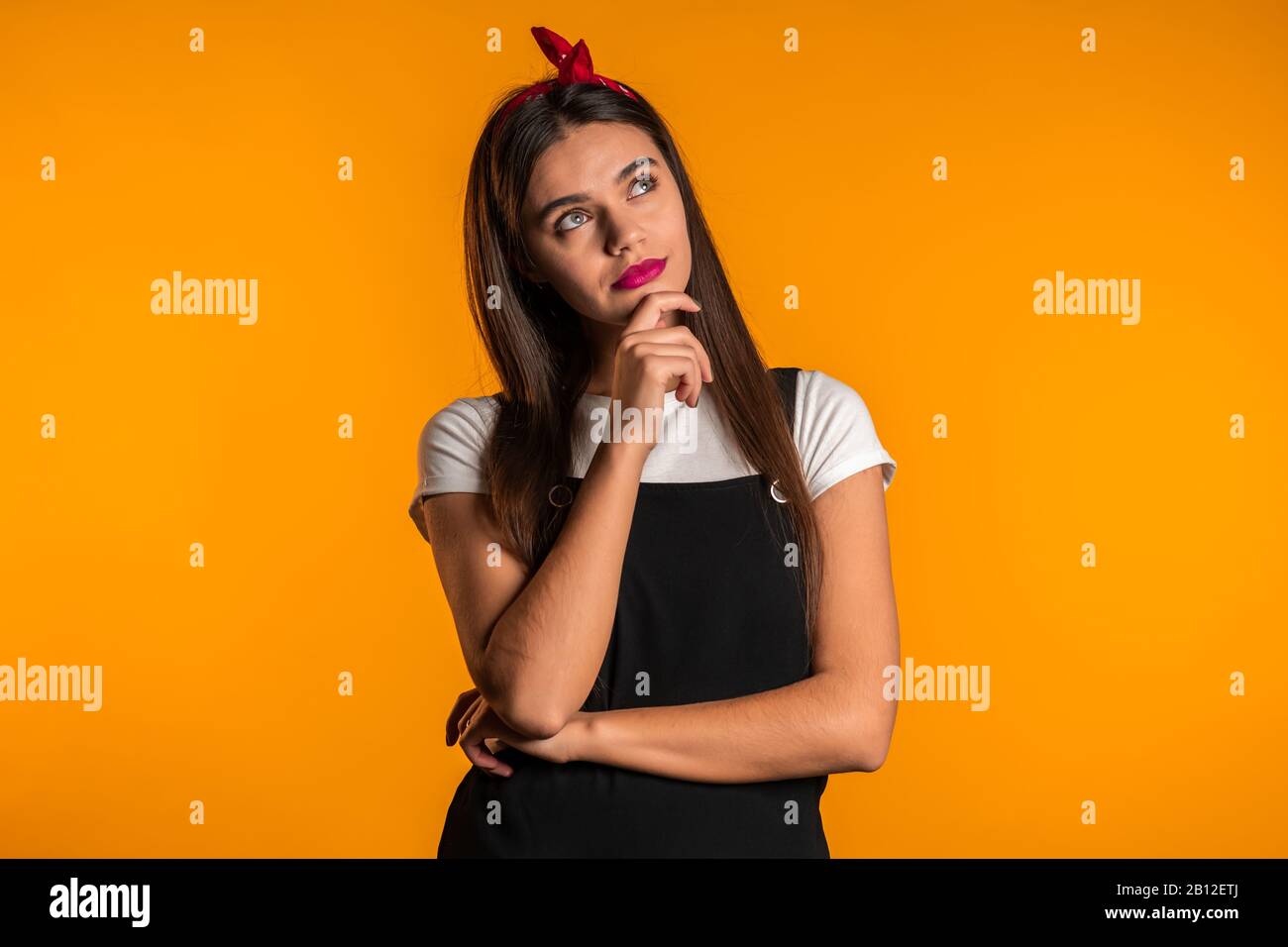 Thinking woman looking up on yellow background. Worried contemplative ...