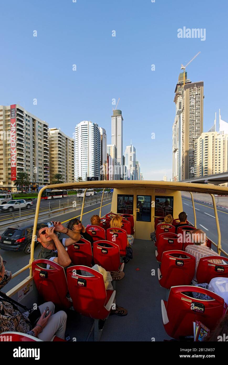 Tourists riding in the BIG BUS on Sheikh Zayed Road,towers,skyscrapers ...