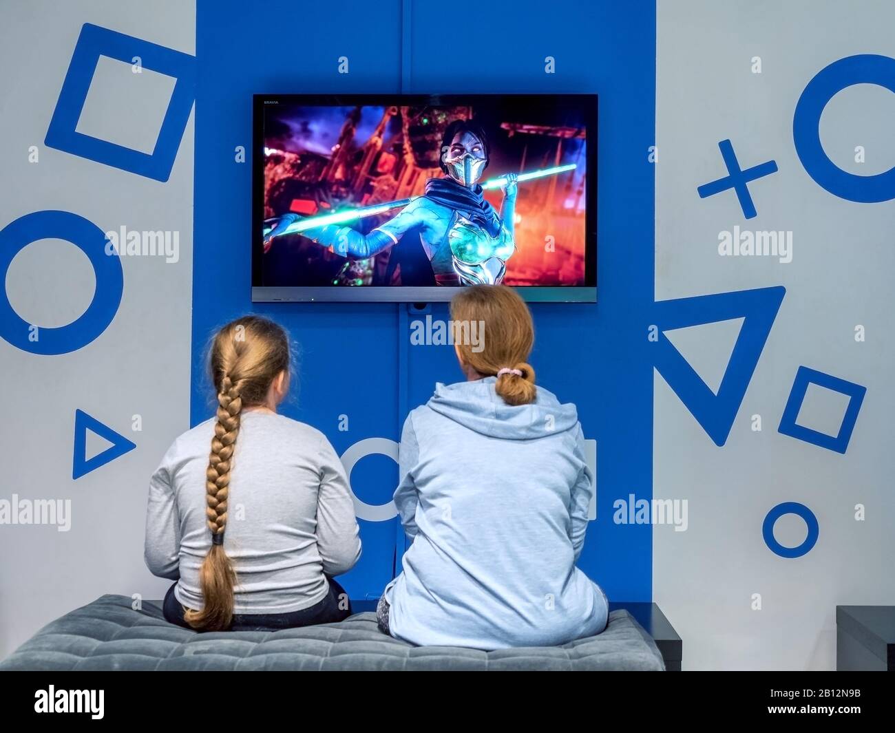 Sochi, Russia - 13 October 2019. Two girls sit on a gray pouf and look ...