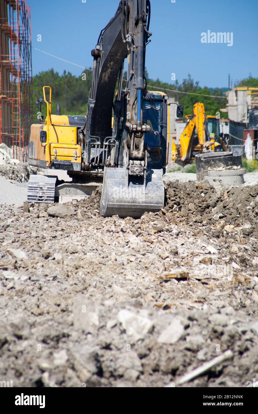 A large construction excavator of yellow color on the construction site ...