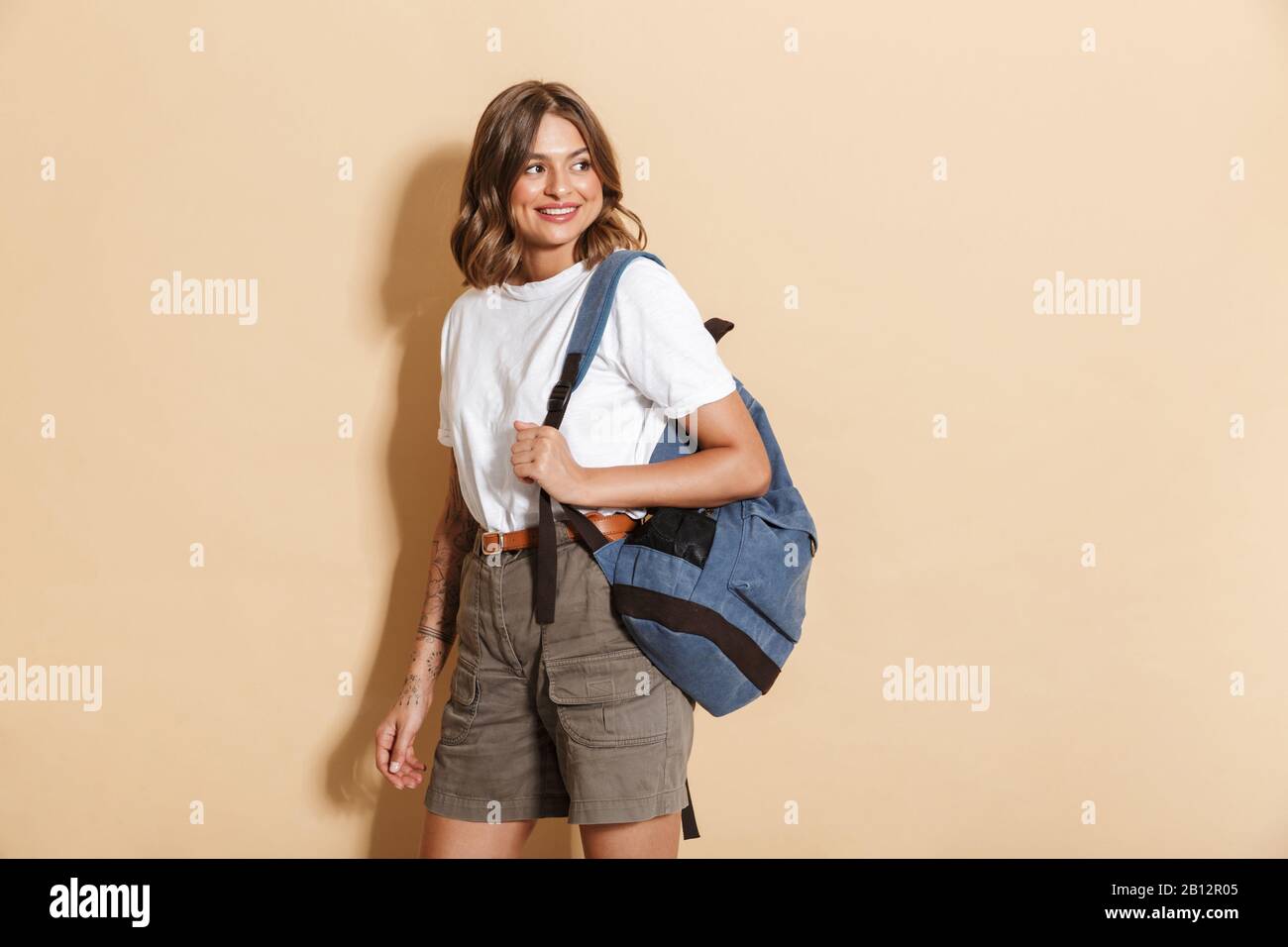 Image of charming teen girl carrying backpack smiling and walking ...