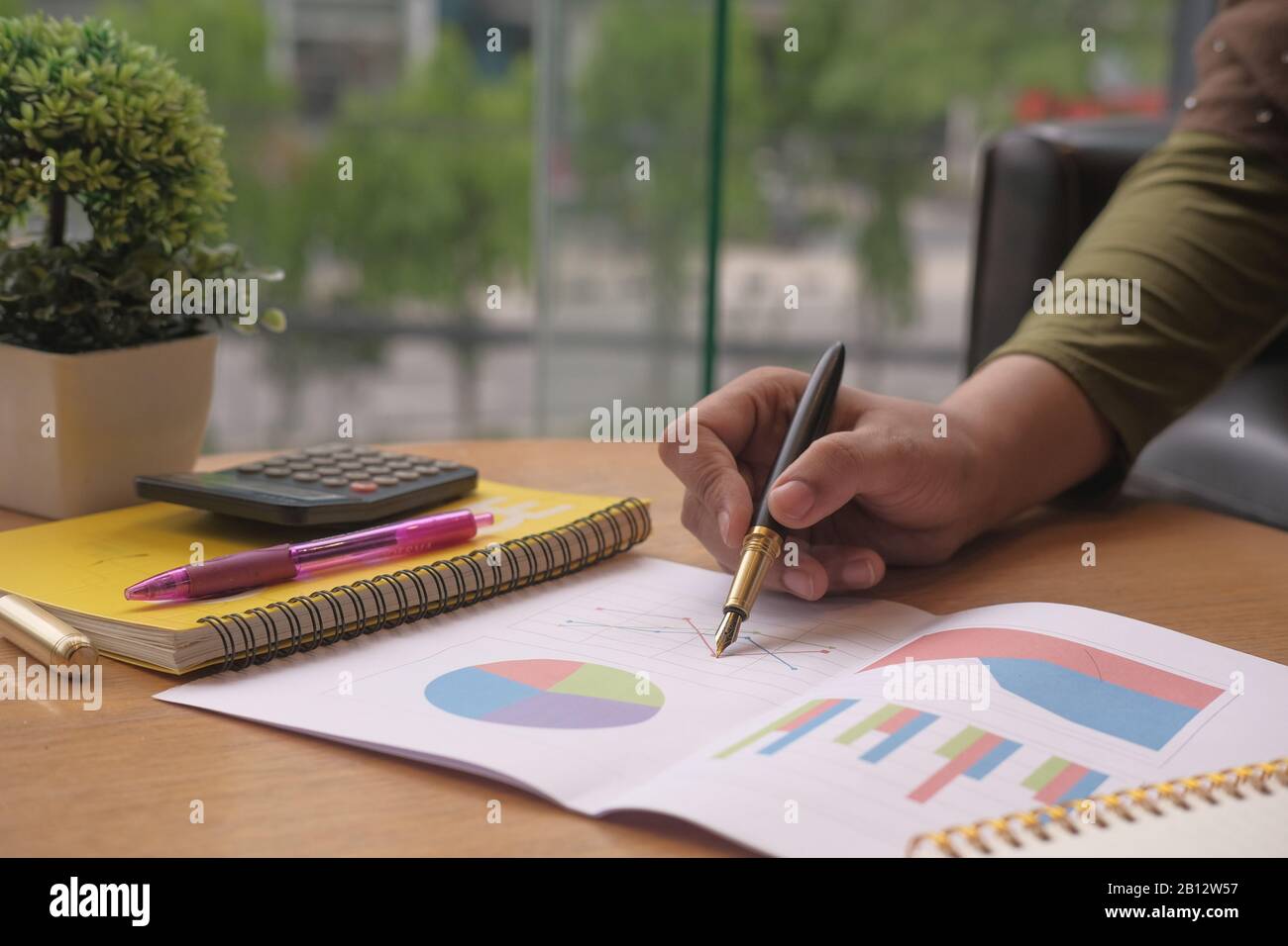 women hand analyzing chart on paper on office desk Stock Photo - Alamy