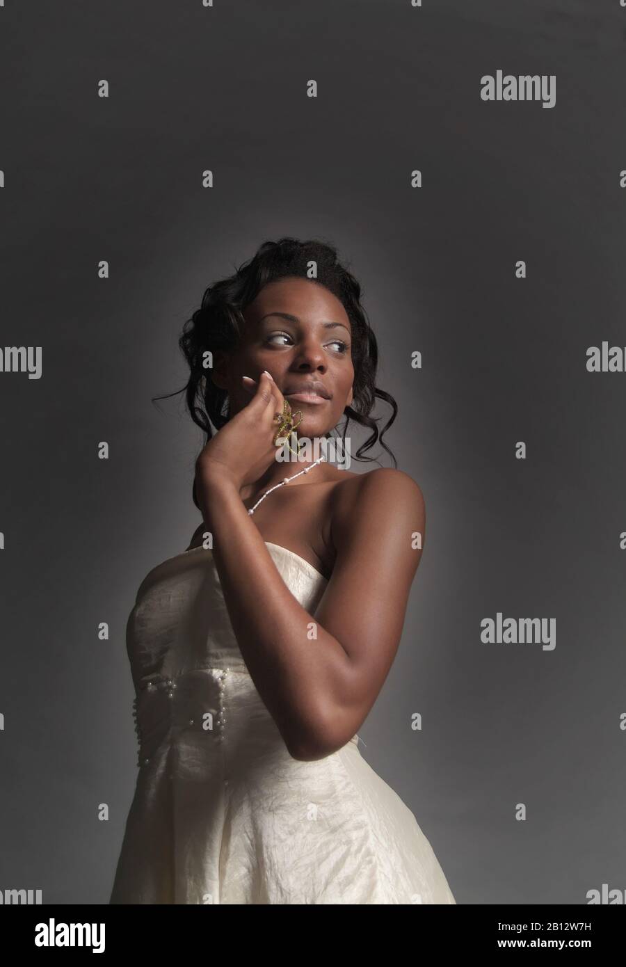 Young dark-skinned woman wearing an ivory-colored dress Stock Photo - Alamy