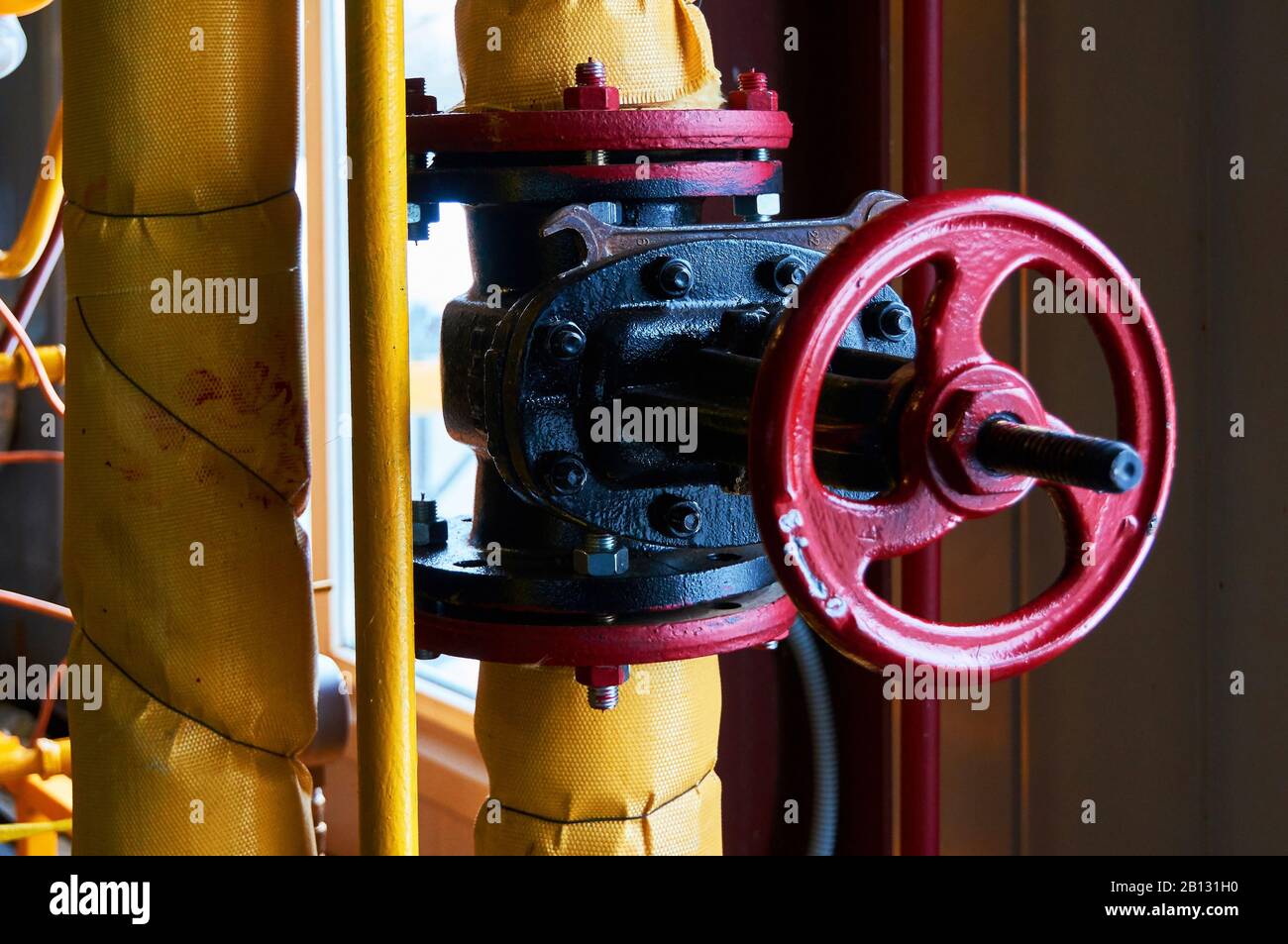 Black valve on yellow heating pipe Stock Photo - Alamy