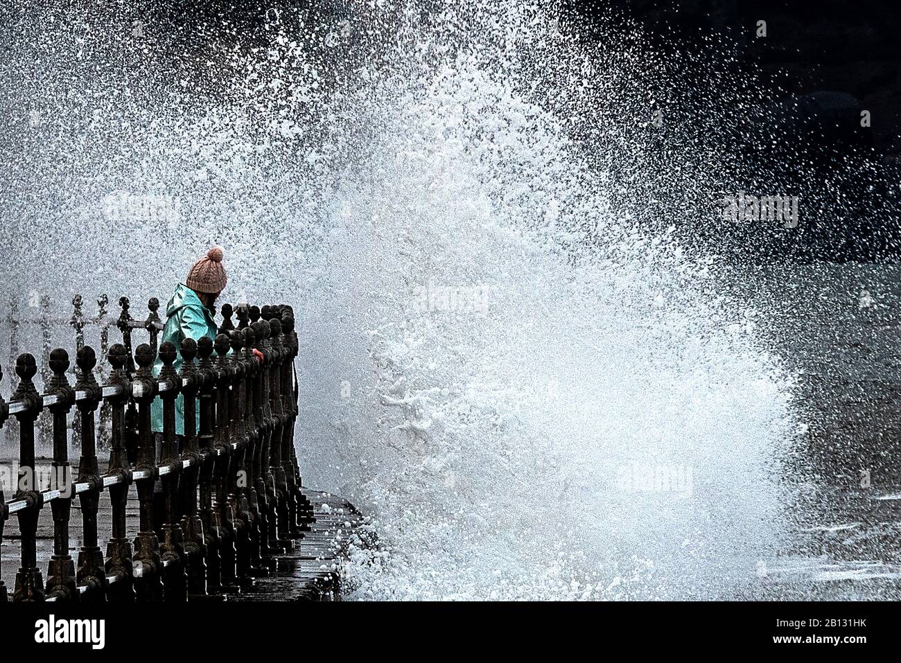 A child watches waves crash in at high tide at Whitby, North Yorkshire ...