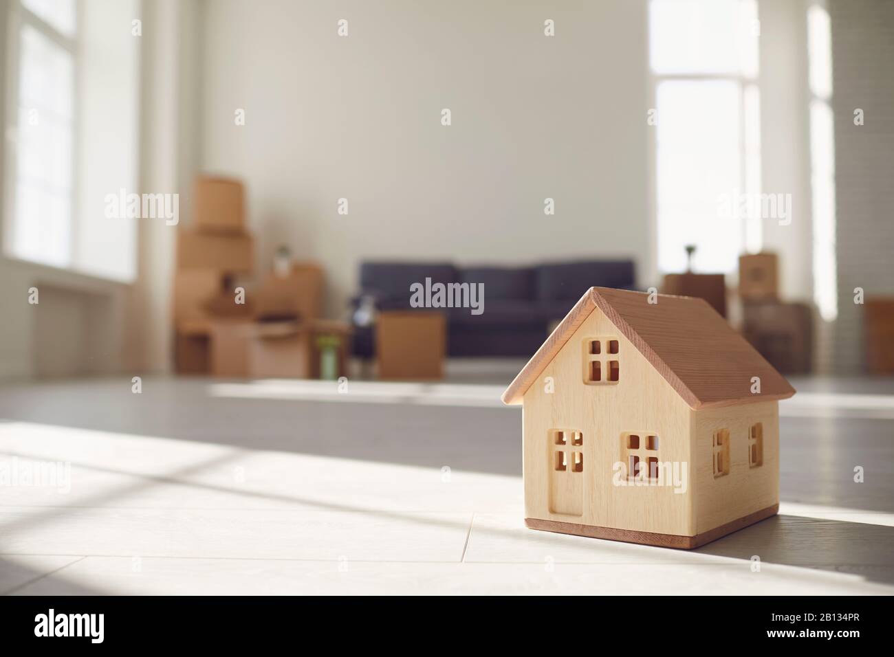 Model of the wooden house on the floor in the new bright sunny house ...