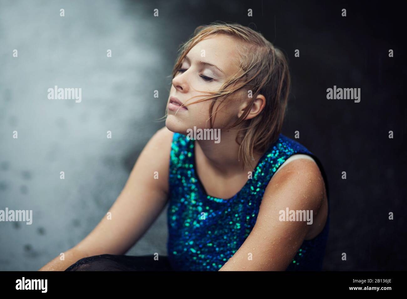Young woman sitting in rain on the road Stock Photo - Alamy