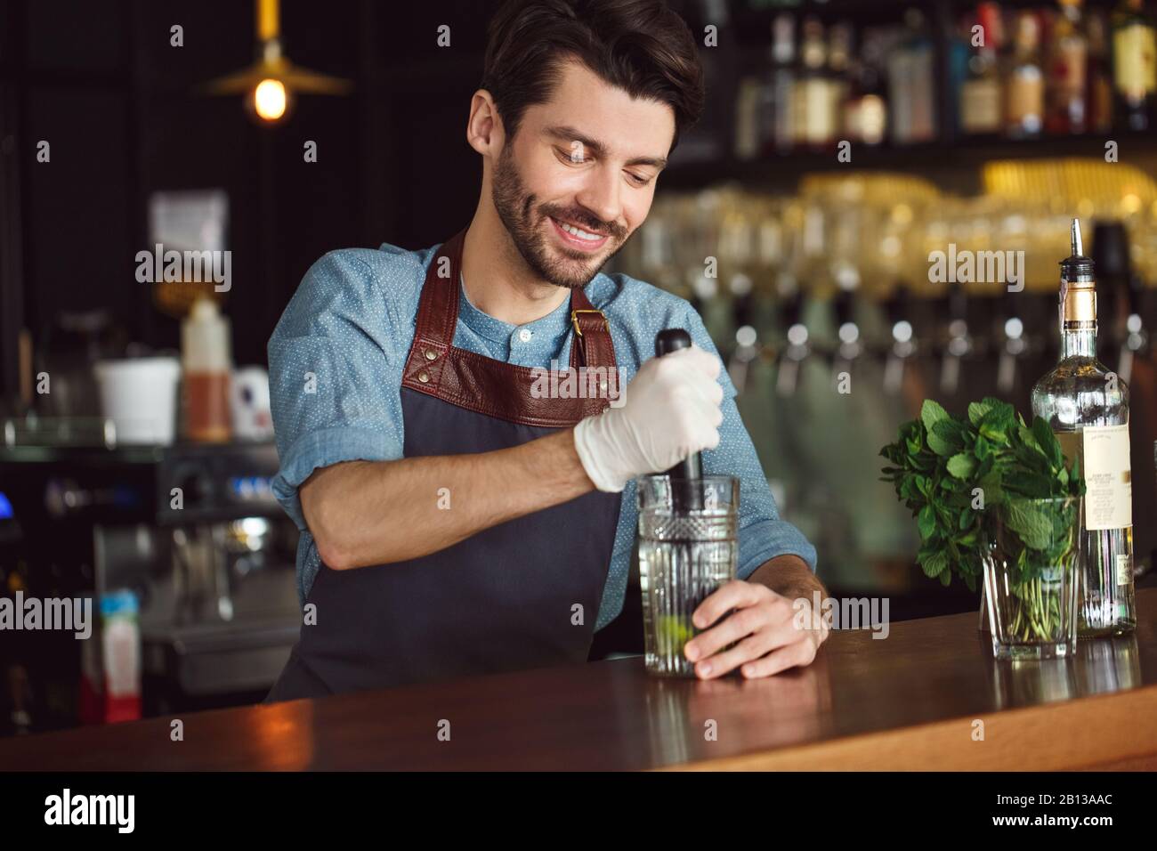 Drink Preparation. Bartender standing at counter squeezing out lime ...
