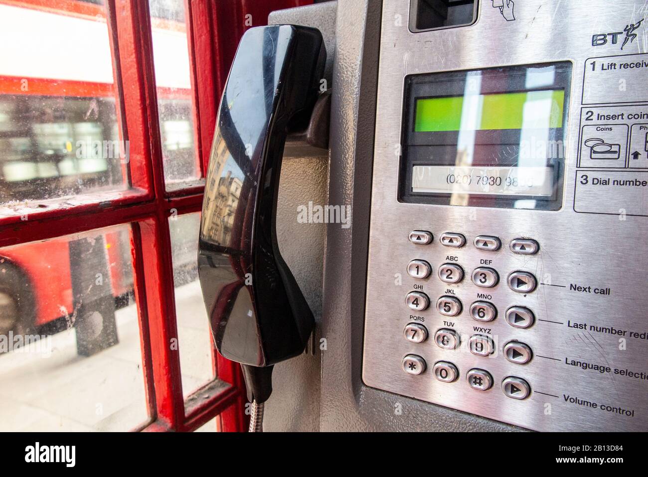 The interior of a payphone in central London with a double decker bus ...