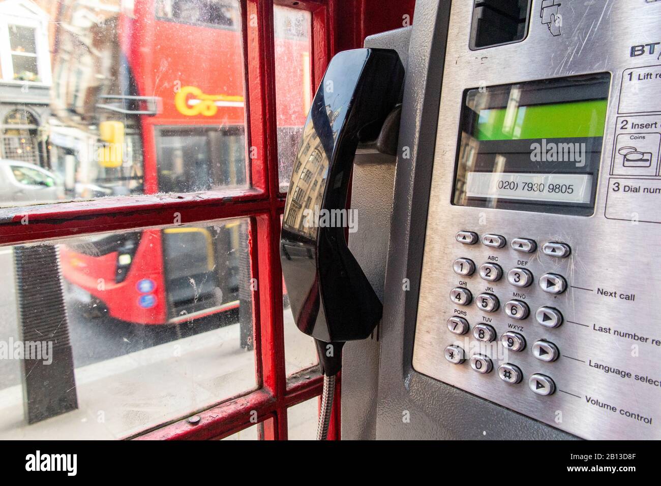 The interior of a payphone in central London with a double decker bus ...