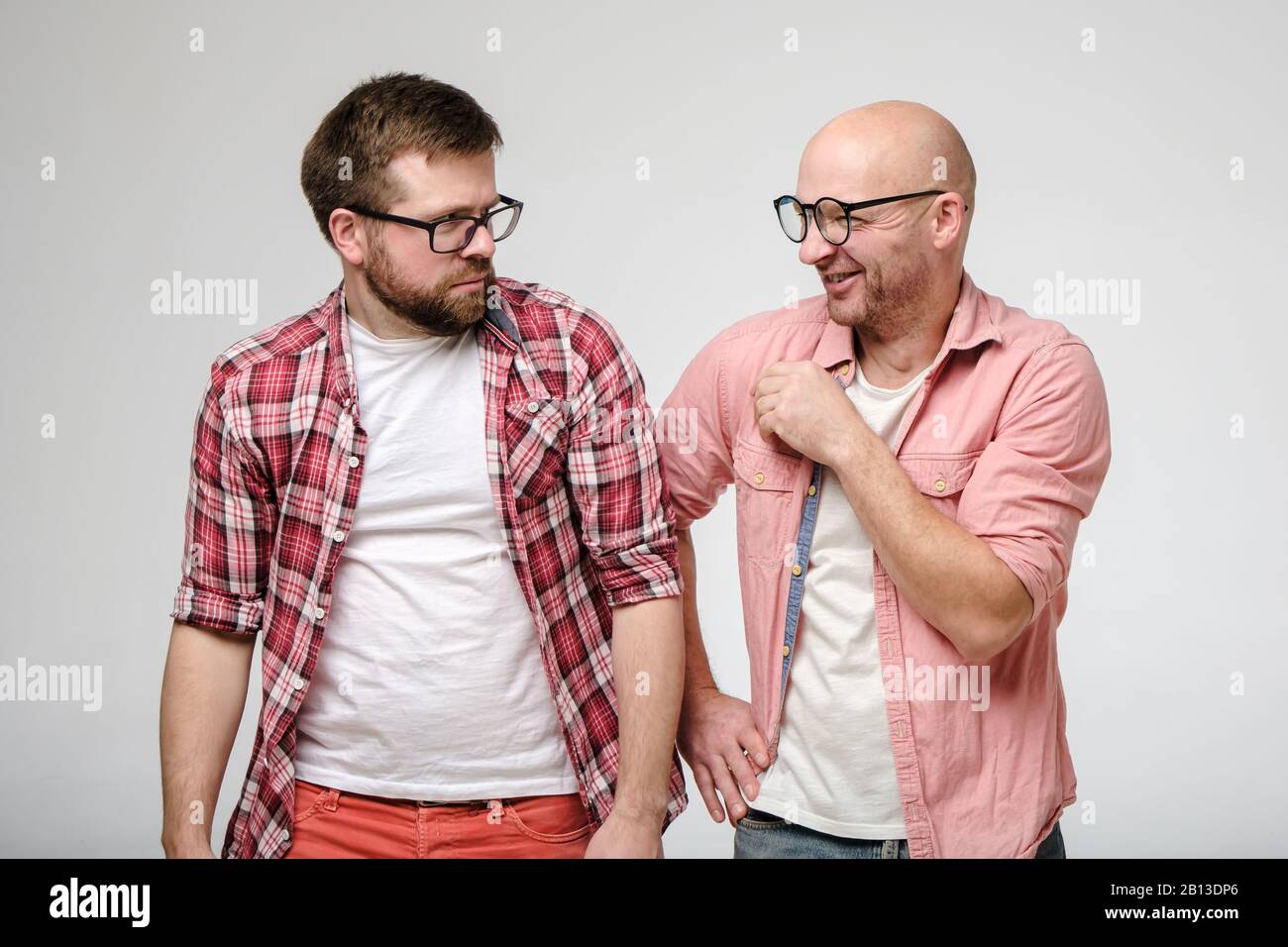 Bald Man Mockingly Laughs At His Bearded Friend Who Does Not Like A