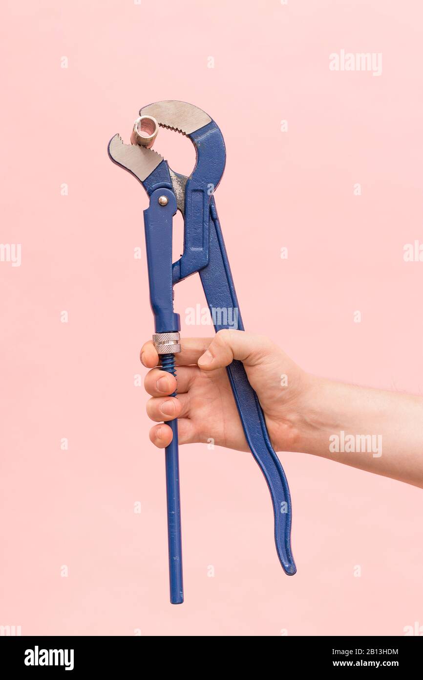 Blue pipe adjustable pipe gas plumbing wrench in a male hand close-up ...