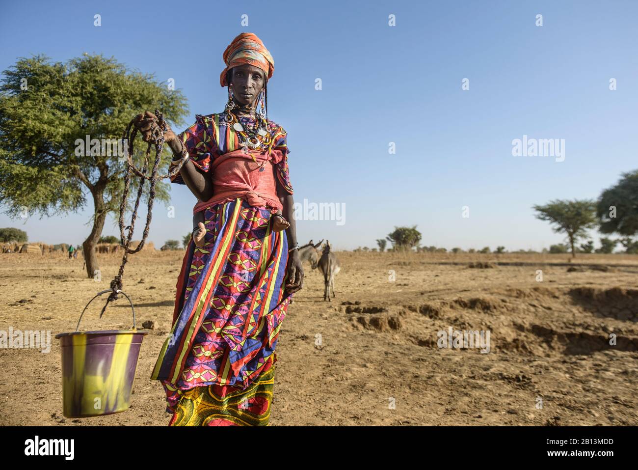 Fulani women gathering water from a hole in the Sahel,Burkina Faso ...
