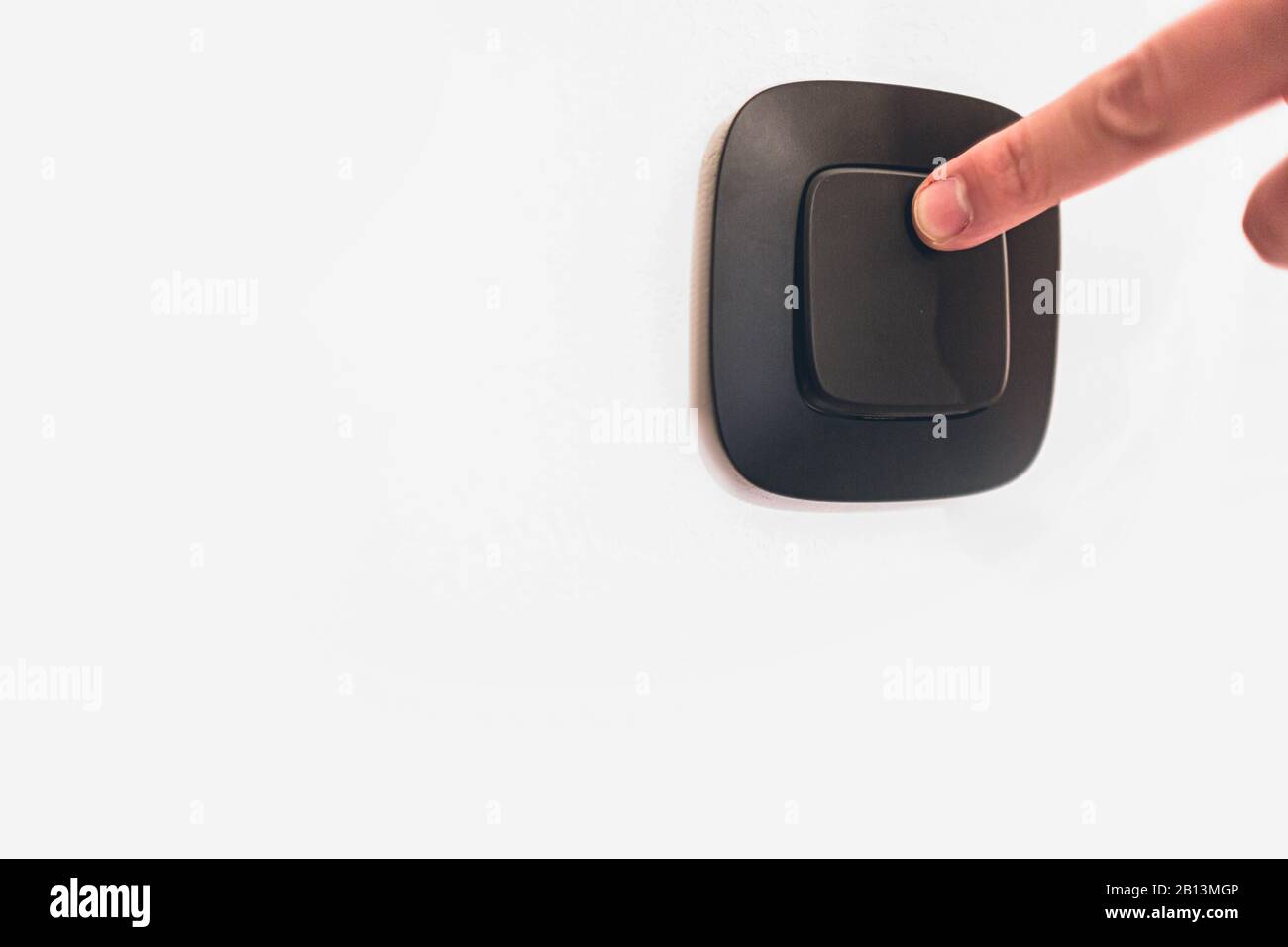 Turning off or turning light switch on wall with finger. Caucasian hand ...