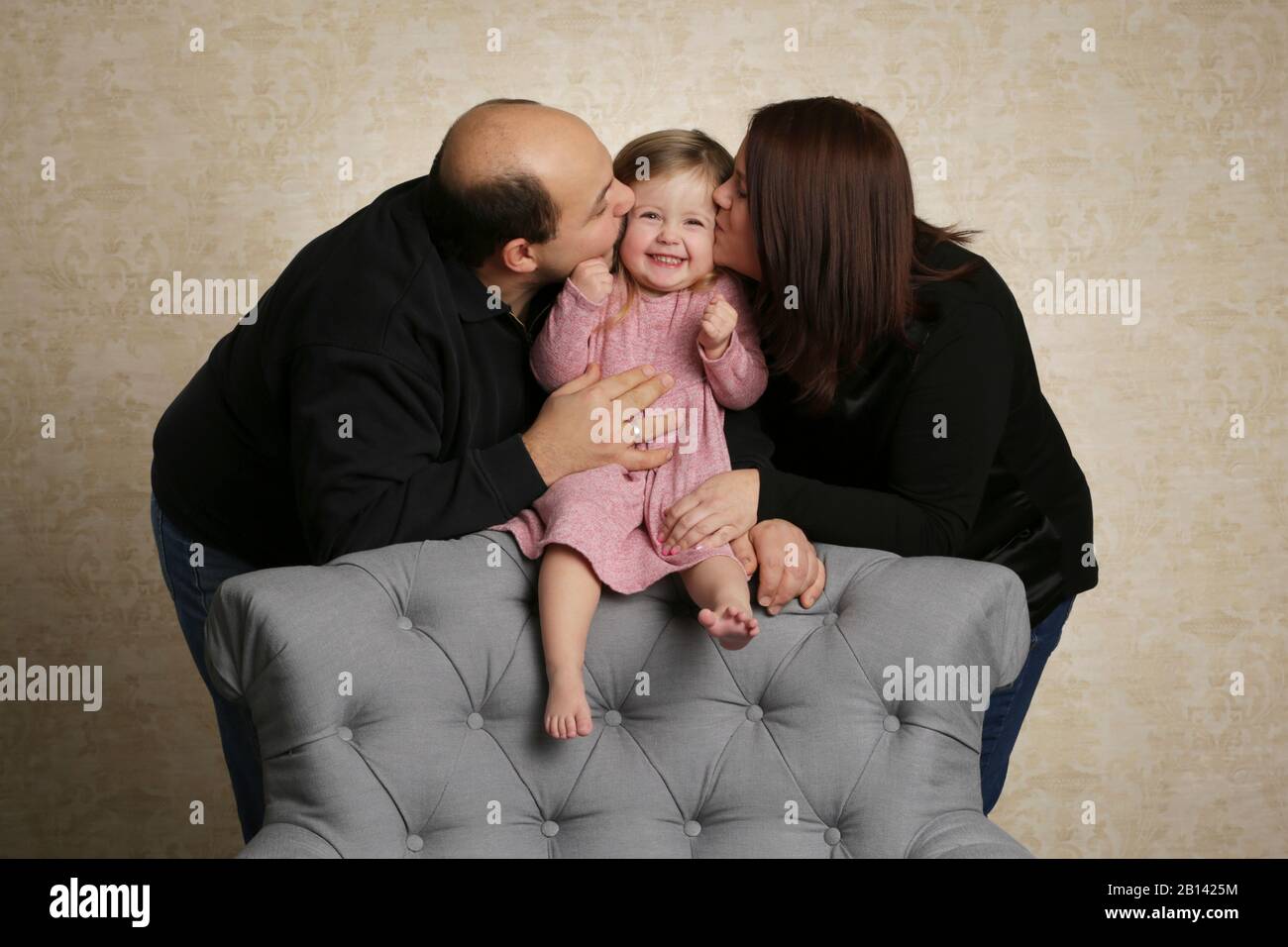 Parents kiss their child Stock Photo - Alamy