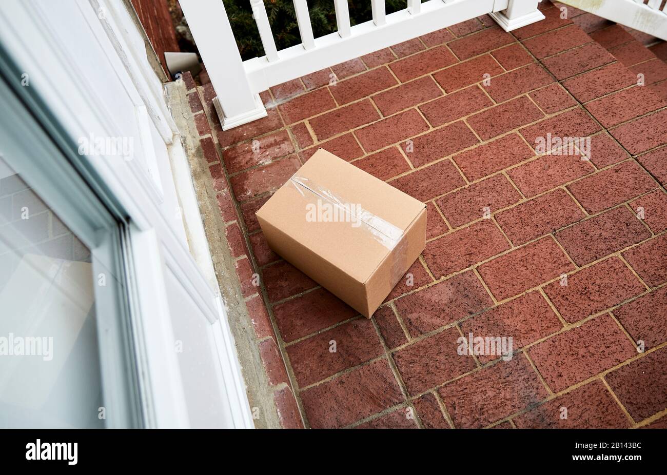 Cardboard box delivered to front door Stock Photo - Alamy