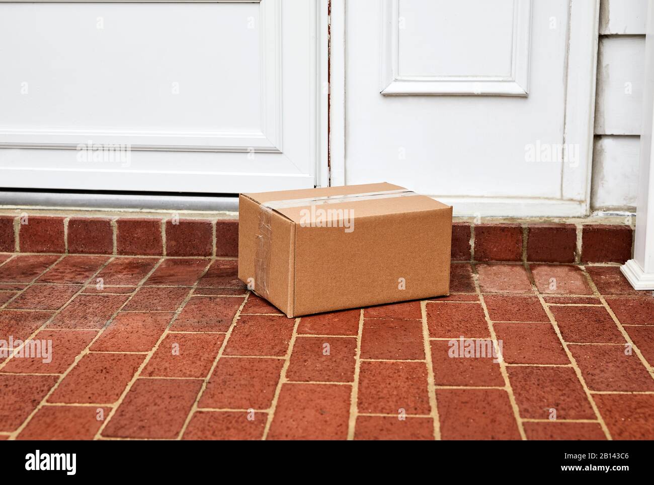 Cardboard box delivered to front door Stock Photo - Alamy