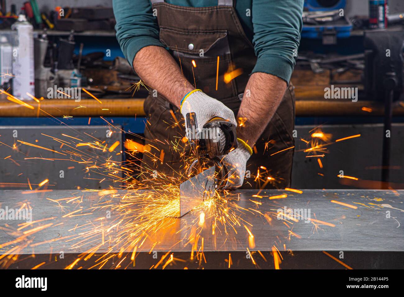 Close-up on the sides fly bright sparks from the angle grinder machine ...