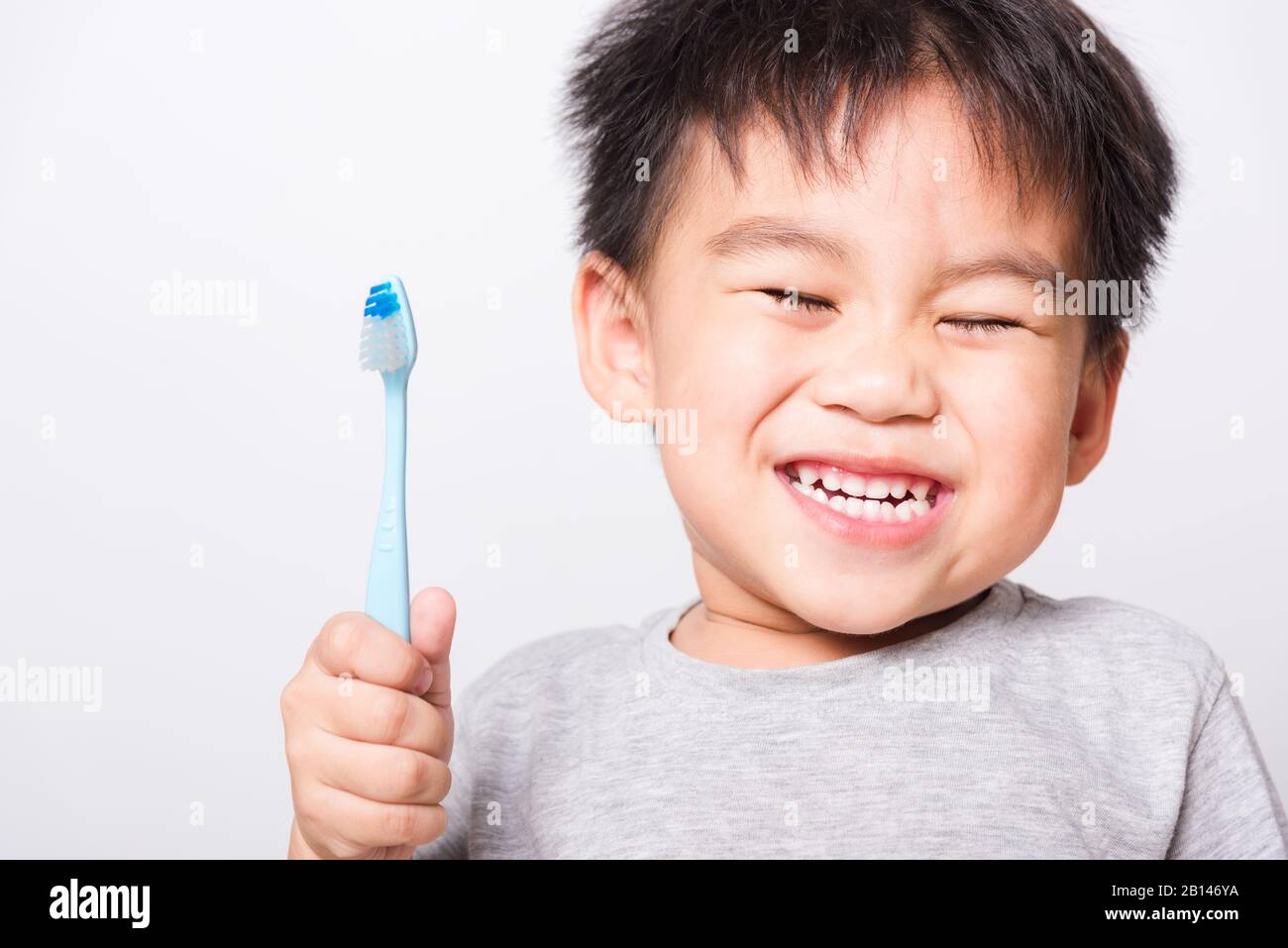 Closeup Asian face, Little children boy hand holds toothbrush he ...