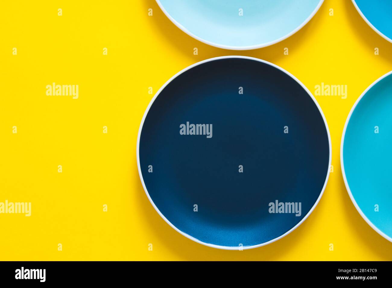 Colorful pastel blue ceramic plates isolated on yellow background Stock ...