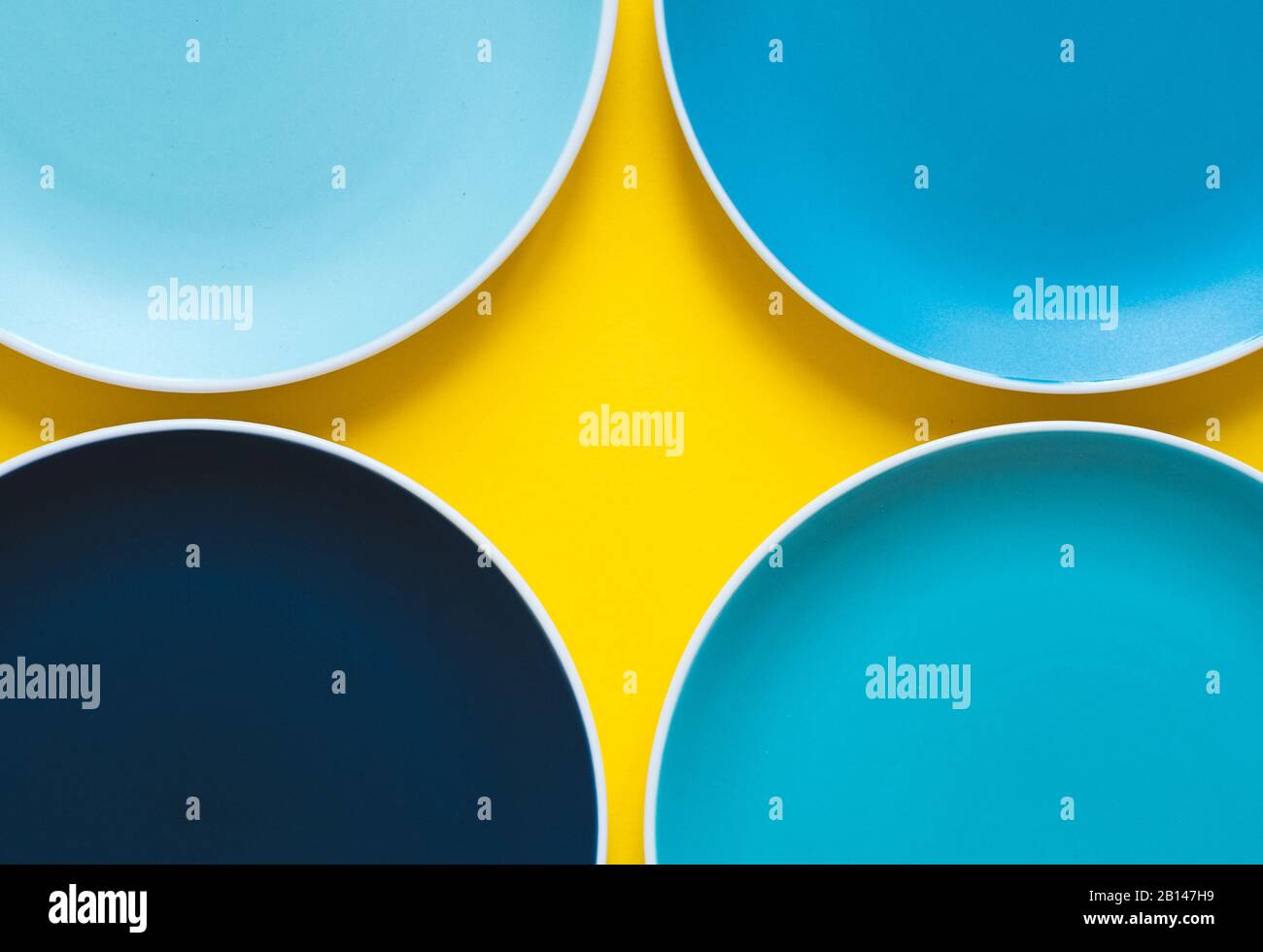Colorful pastel blue ceramic plates isolated on yellow background Stock ...