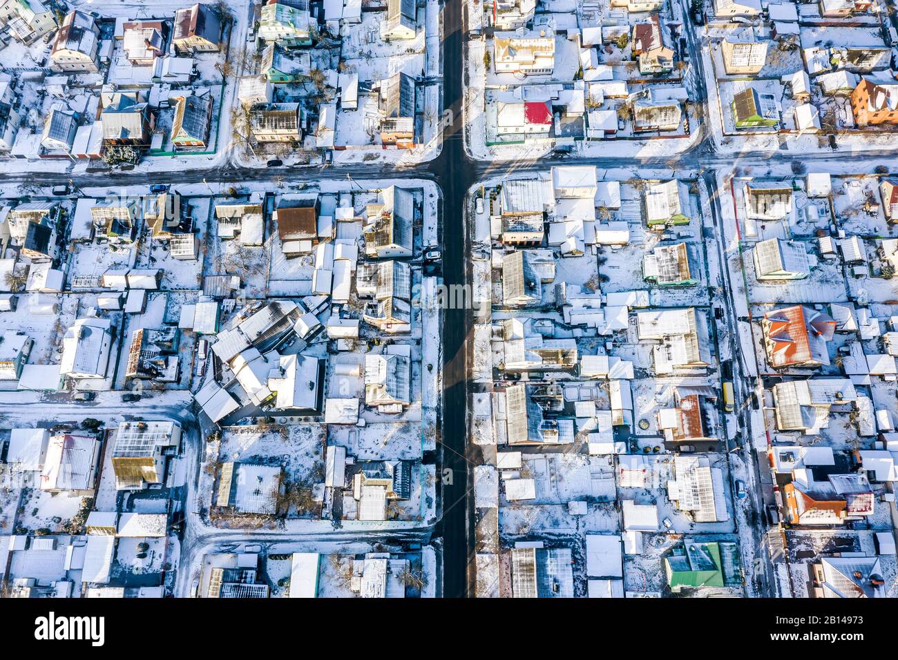 residential area covered by snow in a cold sunny winter day. aerial ...