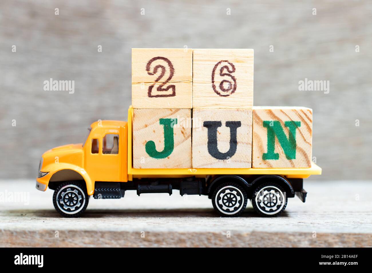 Truck hold letter block in word 26jun on wood background (Concept for ...