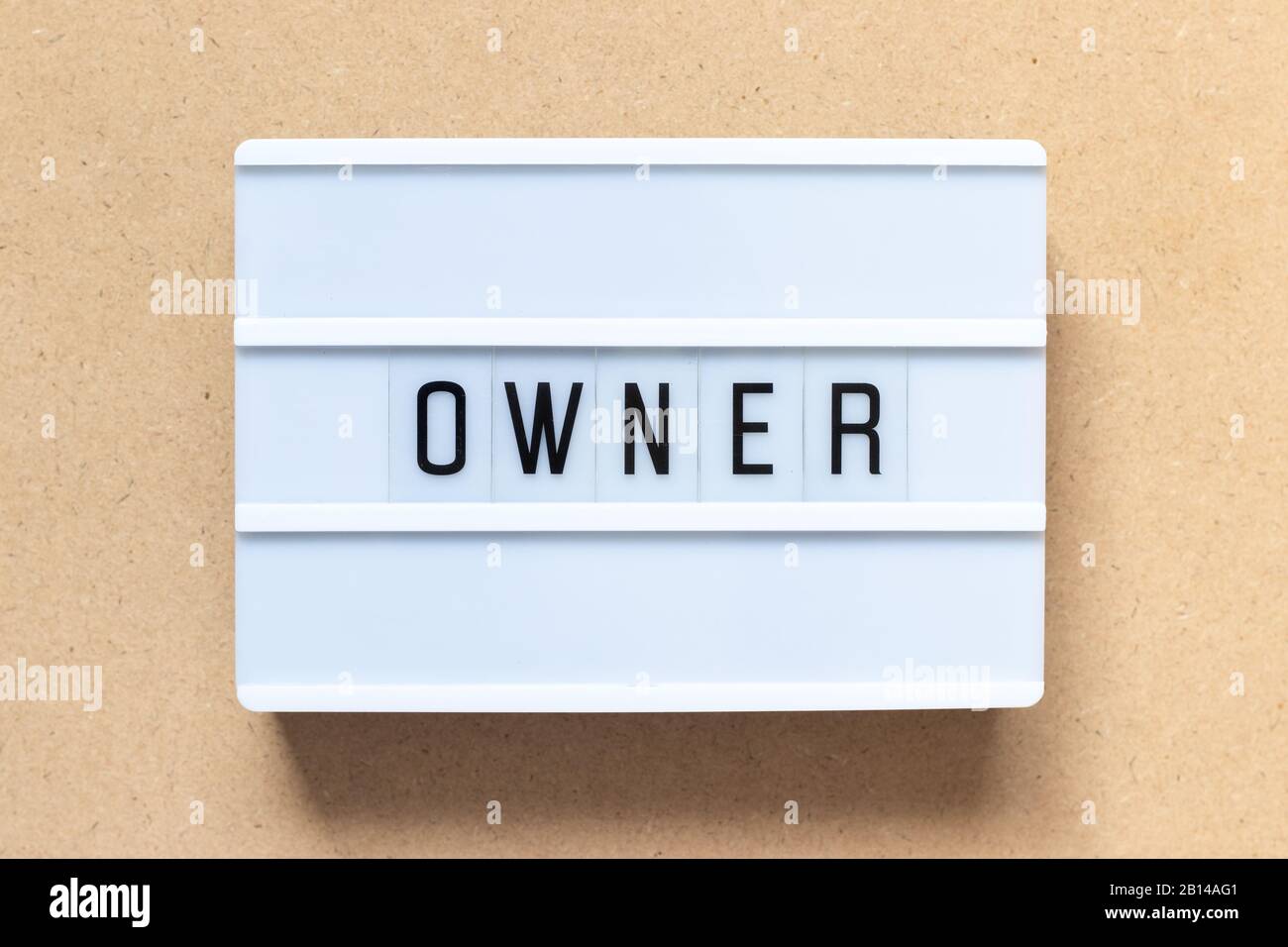 White lightbox with word owner on wood background Stock Photo - Alamy