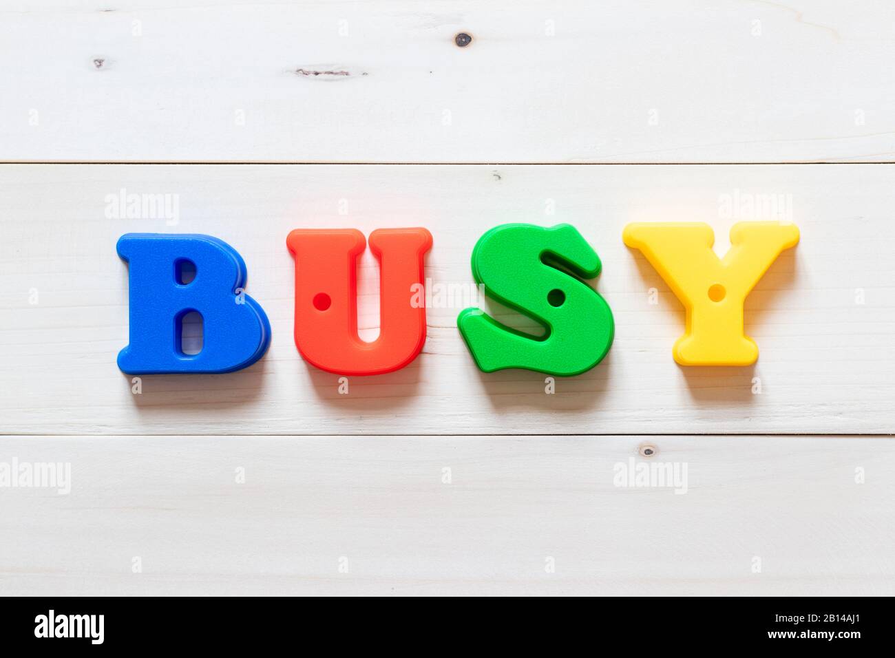 Letter block in word busy on white wood background Stock Photo - Alamy