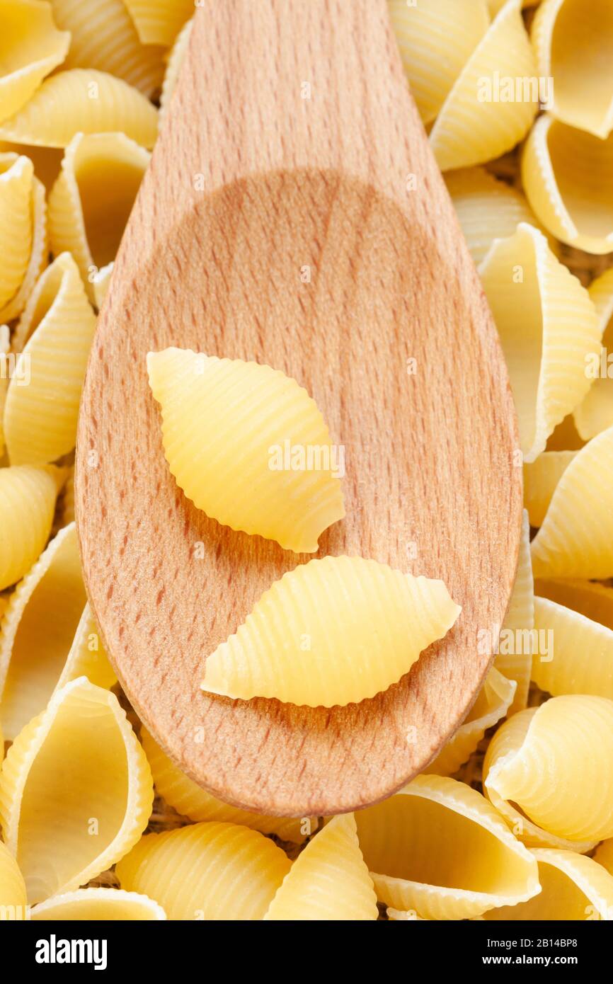 Conchiglie Rigate Pasta in wooden spoon background Stock Photo - Alamy