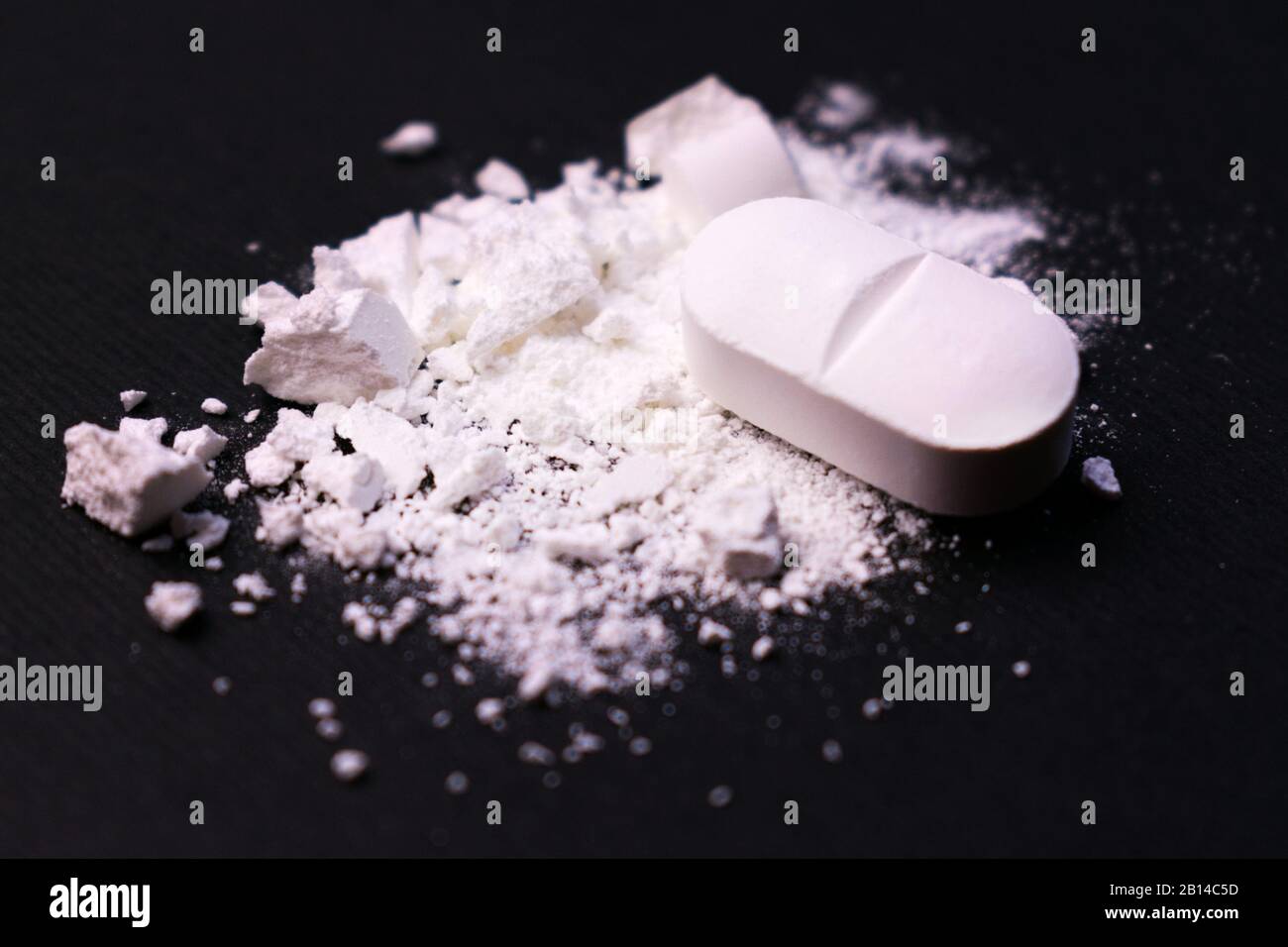 Crushed pill on a black background. Close-up. Drug abuse Stock Photo ...