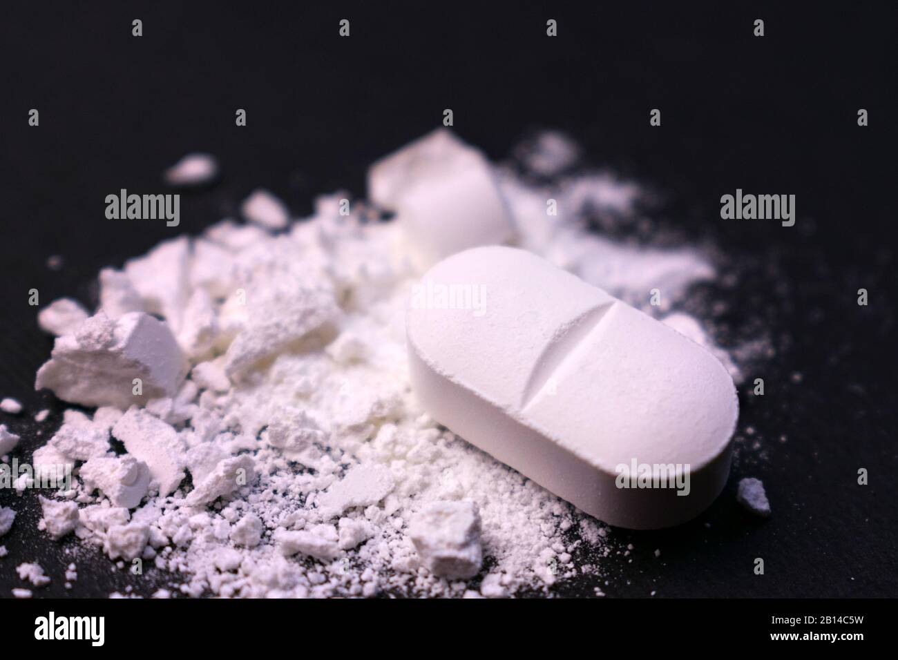 Crushed pill on a black background. Close-up. Drug abuse Stock Photo ...