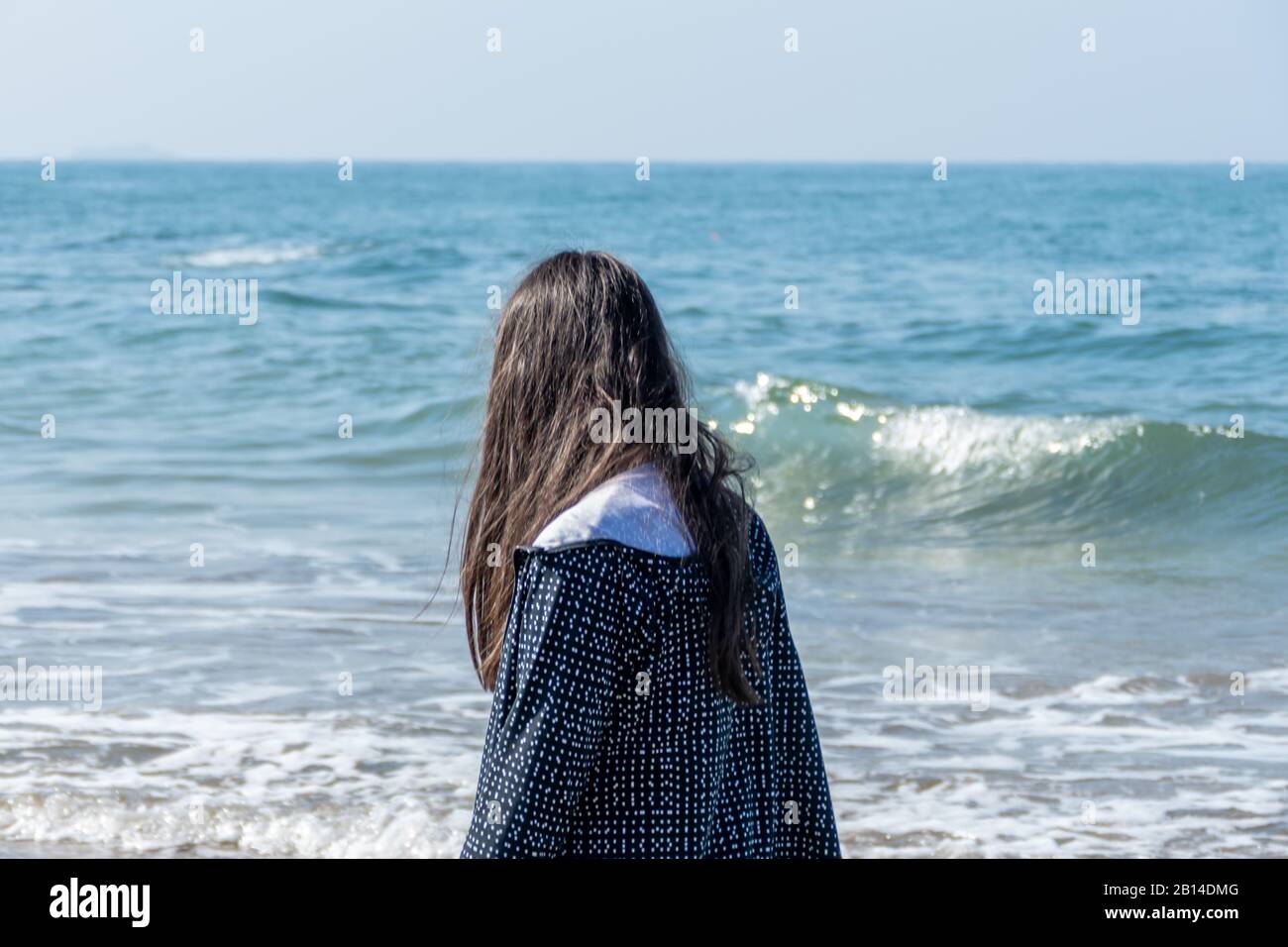 Girl looking at sea from behind Stock Photo - Alamy