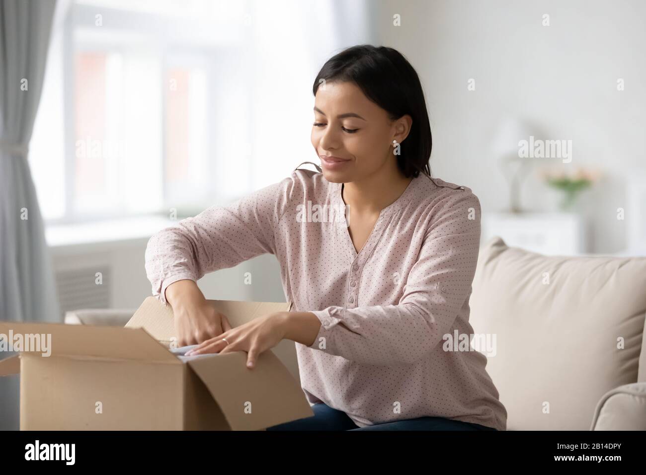 Excited african woman unpacking hi-res stock photography and images - Alamy